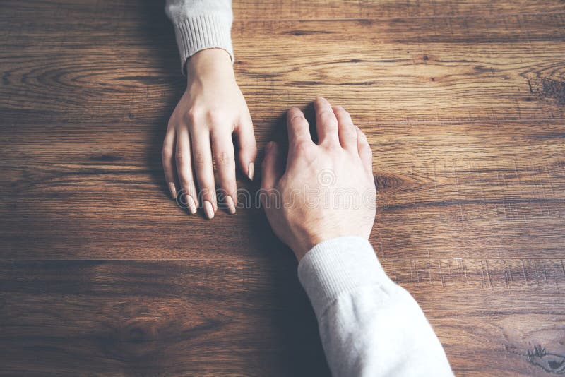A Male and a Female Hand on a Wooden Table Stock Photo - Image of love ...