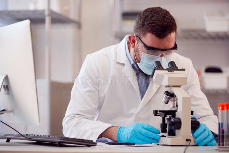Male and Female Lab Workers Conducting Research Using Microscope and ...