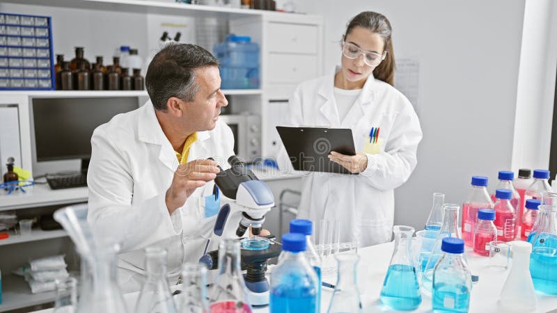 Male and Female Scientists Working Together in Lab, Serious ...