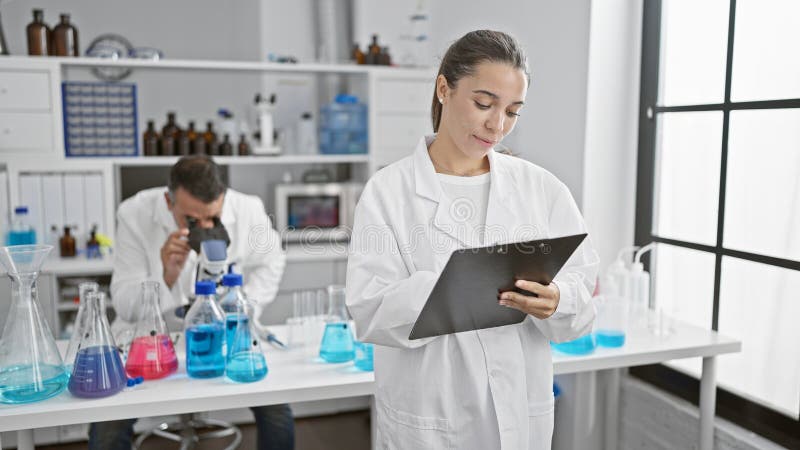 Male and Female Scientists Working Together in Lab, Serious ...