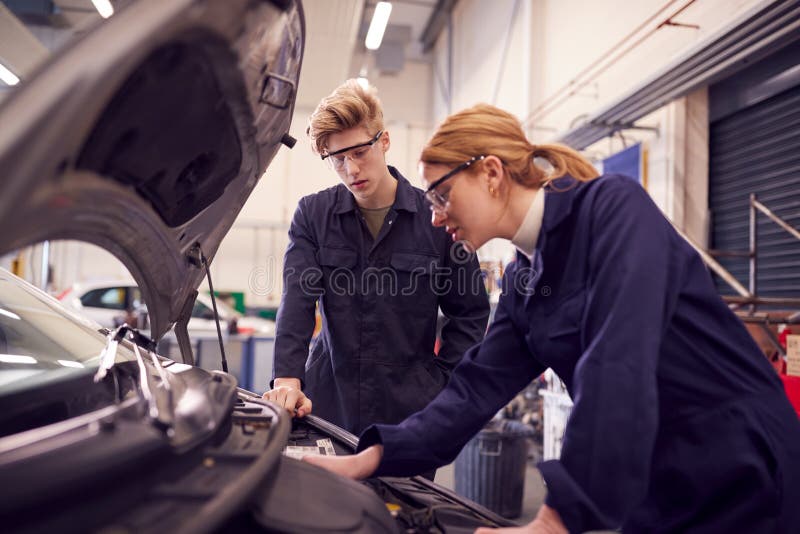 Male and Female Students Looking at Car Engine on Auto Mechanic ...