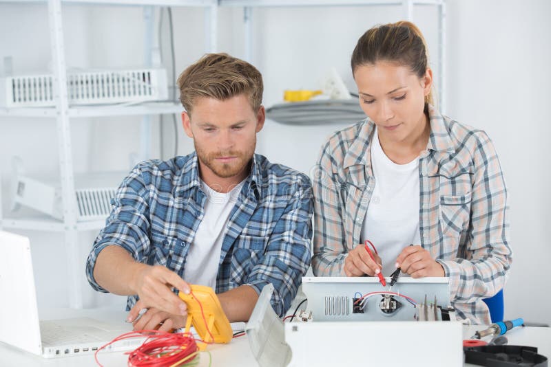Male and Female Technicians Using Multimeter To Test Electrical ...
