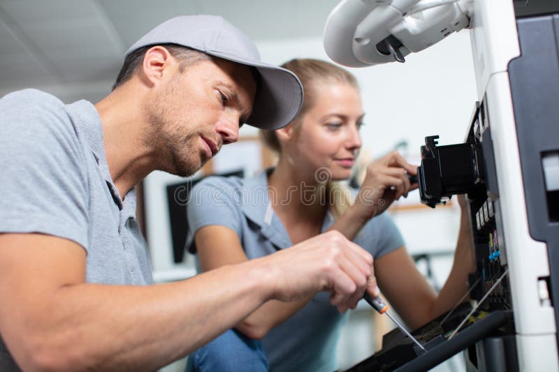 Male and Female Technicians Working on Photocopier Stock Photo - Image ...