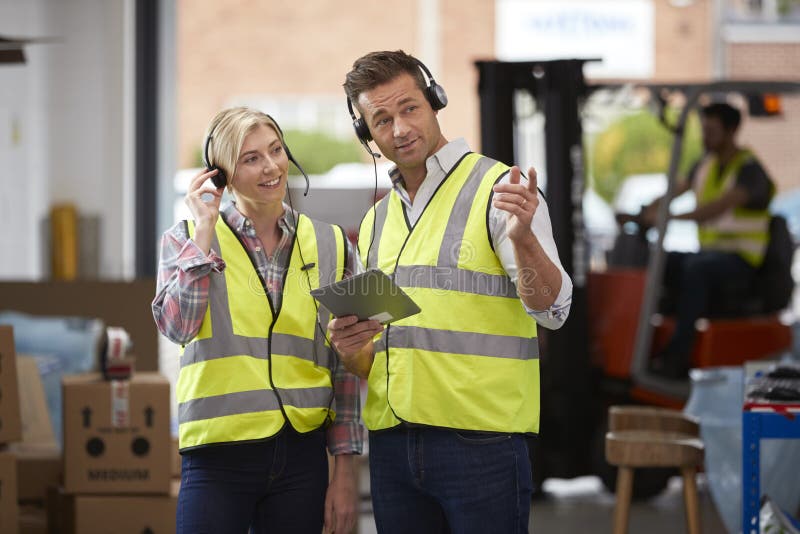 Male and Female Workers Wearing Headsets in Logistics Distribution ...