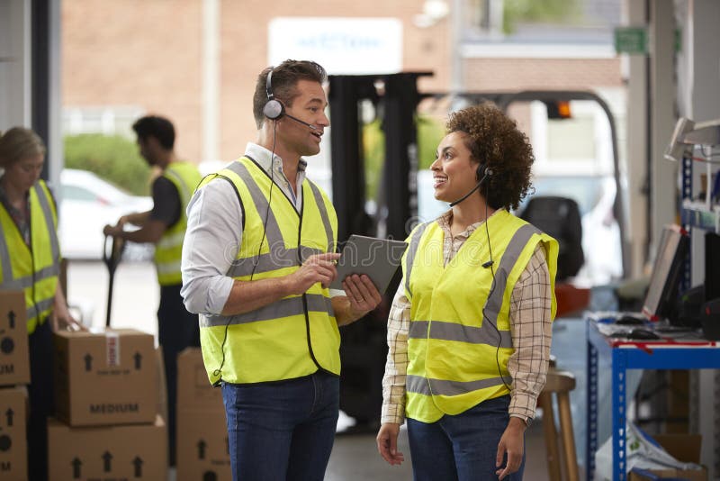 Male and Female Workers Wearing Headsets in Logistics Distribution ...