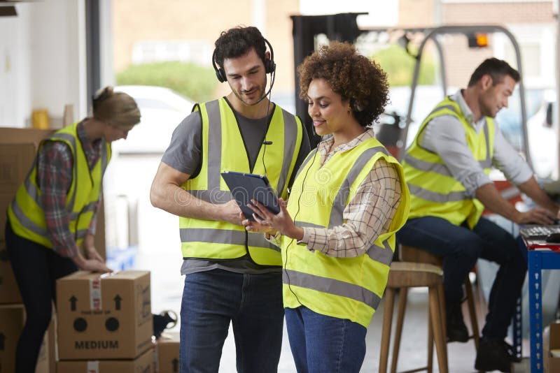 Male and Female Workers Wearing Headsets in Logistics Distribution ...