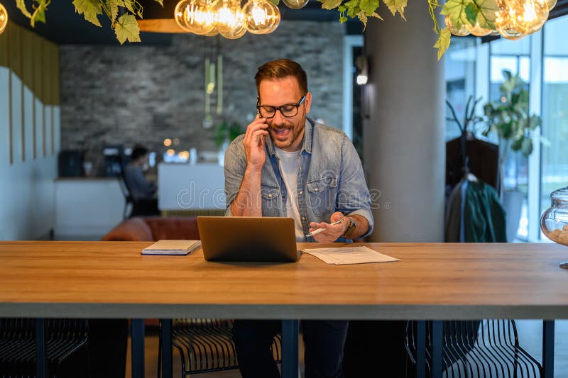 Male Freelancer Discussing Over Phone Call while Working Over Wireless ...