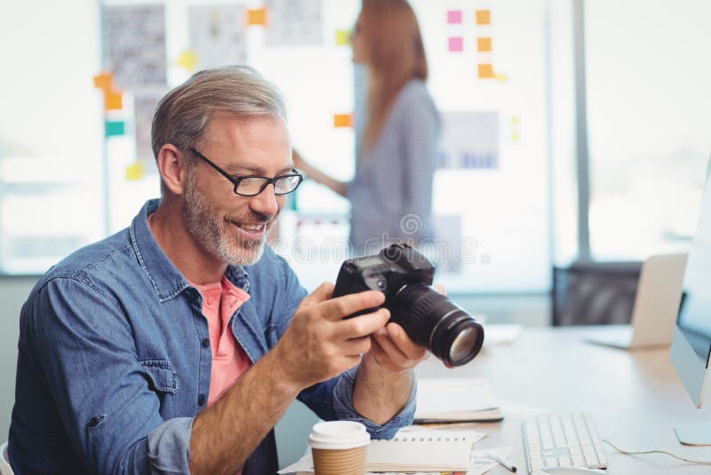 Male Graphic Designer Looking at Pictures on Digital Camera Stock Image ...