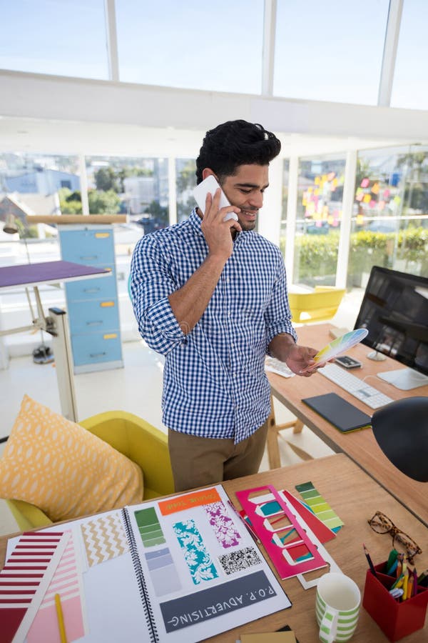 Male Graphic Designer Talking on Mobile Phone at Desk Stock Image ...