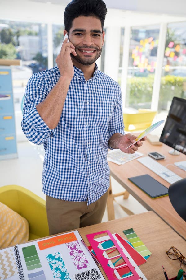 Male Graphic Designer Talking on Mobile Phone at Desk Stock Photo ...