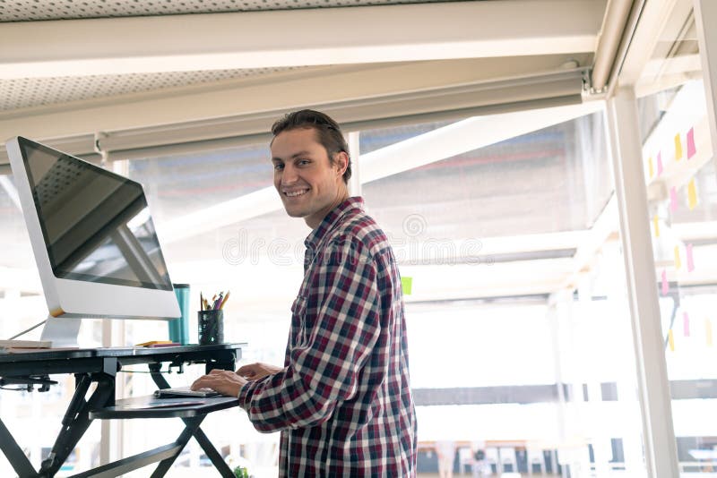 Male Graphic Designer Working on Computer at Desk in Office Stock Photo ...