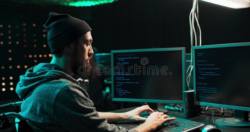 Male Hacker Using Keyboard To Type A Dangerous Malware Into Bank System Hacker Breaks Into Stock