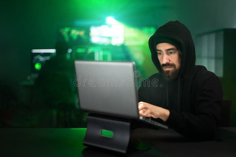 Male Hacker Using Laptop Typing Bad Data into Computer Online System ...