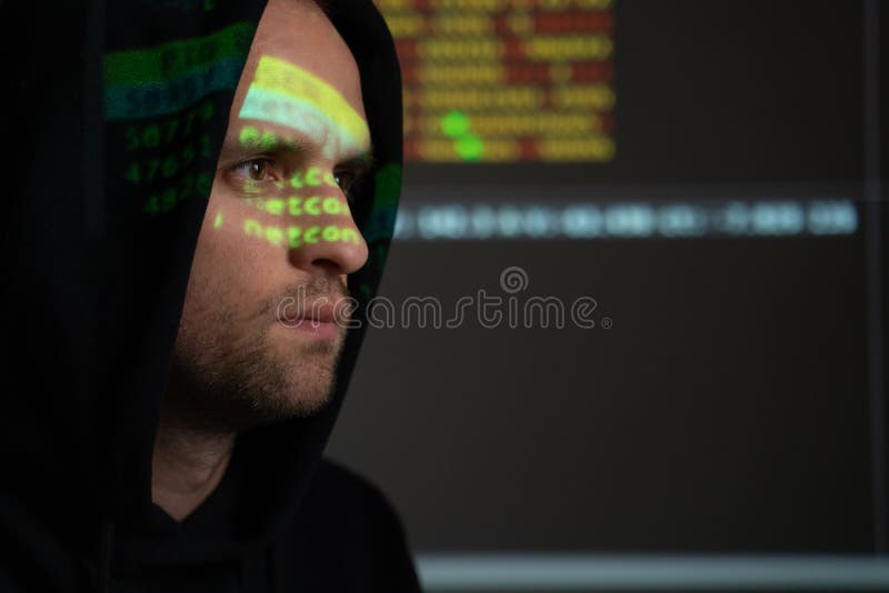 Male Hacker Working on a Computer while Green Code Characters Reflect ... Male Hacker Working on a Computer while Green Code Characters Reflect ...