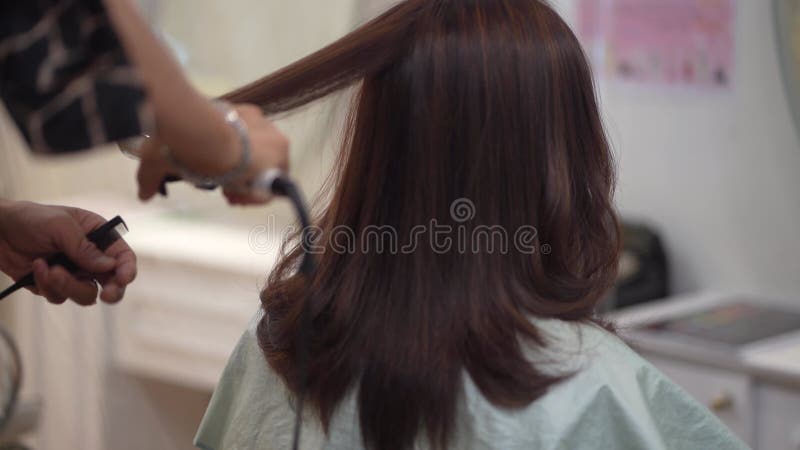Male Hairdresser Applying A Hair Iron To A Woman S Hair Stock Footage
