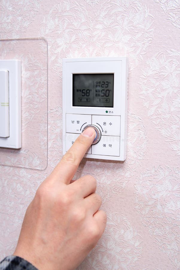 A Male Hand Adjusting the Room Temperature in Winter. Stock Photo ...