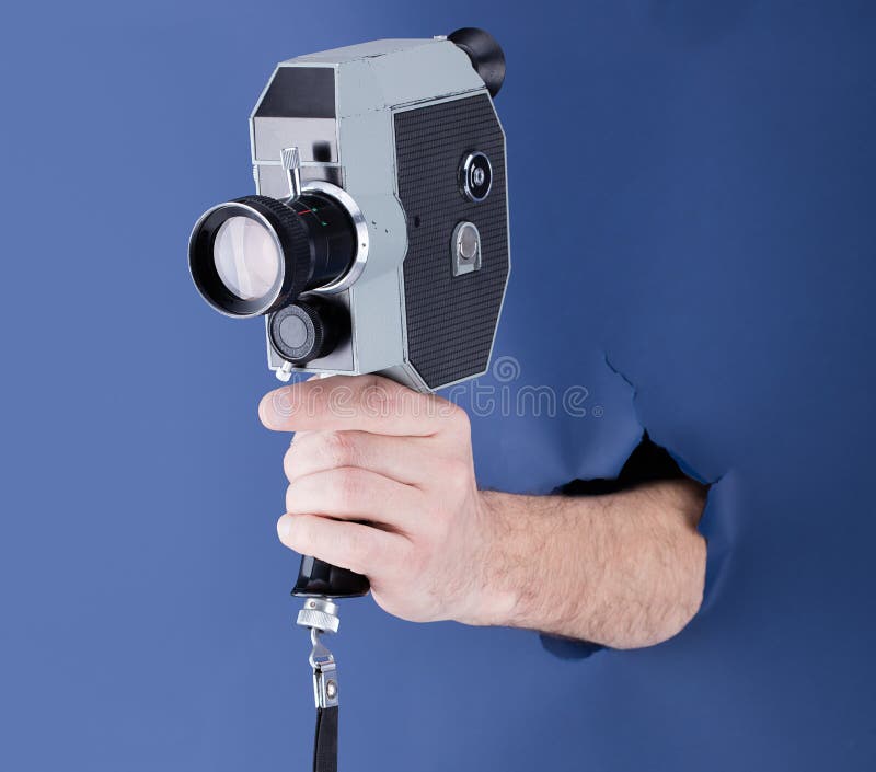 Male Hand Breaking through the Blue Paper Background and Holding Retro ...