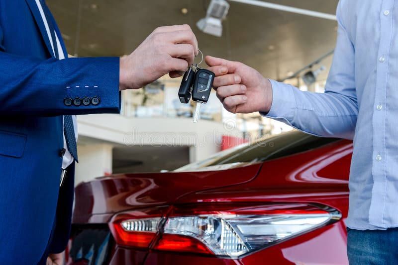Male Hand with Car Keys Against New Car in Showroom Stock Photo - Image ...