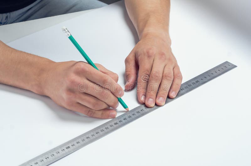 Male Hand Draws a Pencil Under a Ruler on a White Sheet of Paper Stock ...