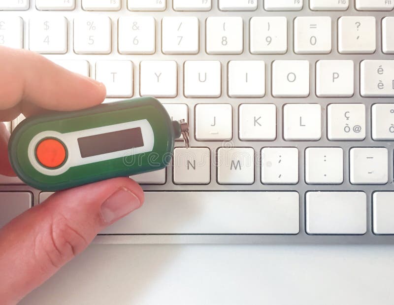 Male Hand Holding a Bank Code Generator on a White Computer Keyboard ...