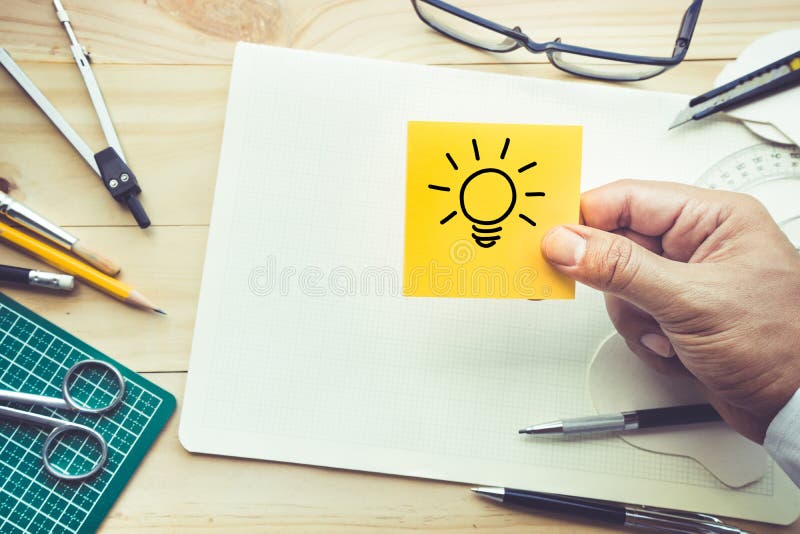 Male Hand Holding Notepad with Light Bulb on Work Table Stock Image ...