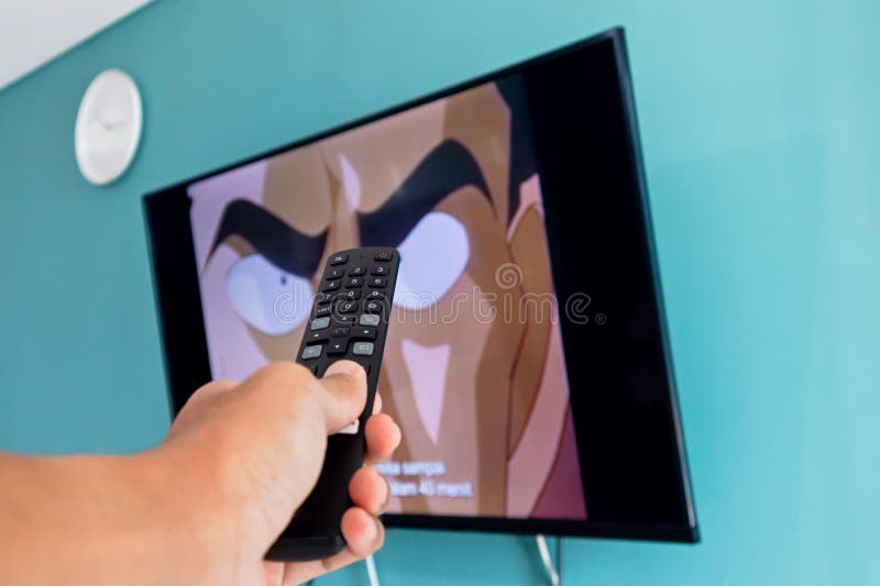 Male Hand Holding TV Remote Control Directed on the Television Inside ...