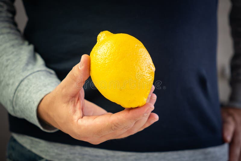 Male Hand Holds a Yellow Lemon. Man Eats a Lemon Stock Image - Image of ...