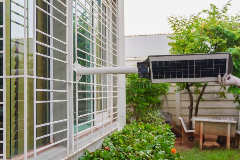 Male Hand Installing Solar Cell at Side of House for Saving Energy ...