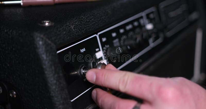 Male Hand Plugging in Guitar Cord Cable into the Input Jack of Amplifie ...