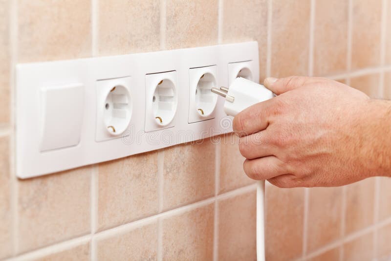 Hand Plugging a Power Cord into Electrical Wall Fixture Stock Image ...