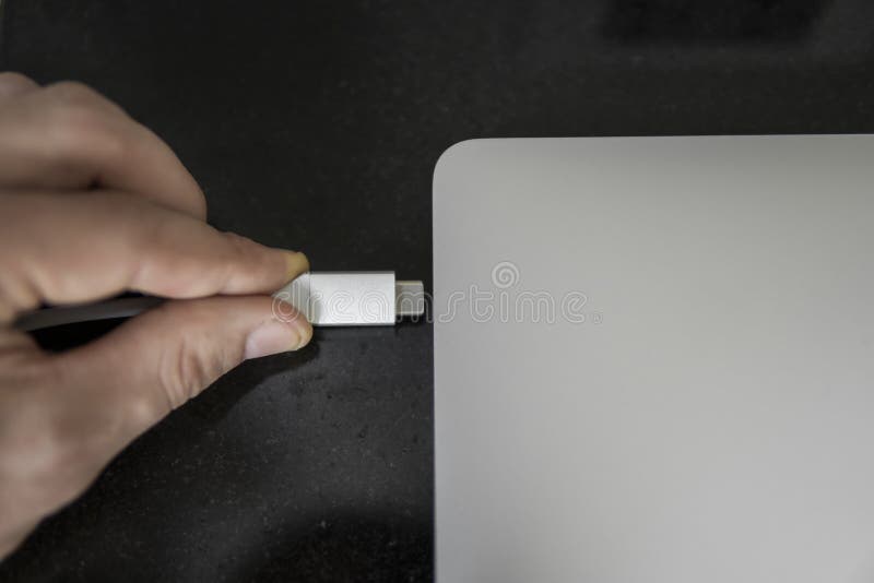 Male Hand Plugging White USB-C Type C Cable into a Port on a Grey ...