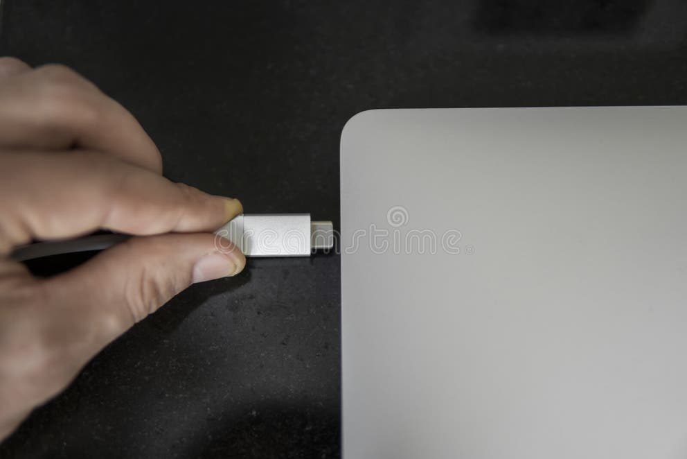 Male Hand Plugging White USB-C Type C Cable into a Port on a Grey ...