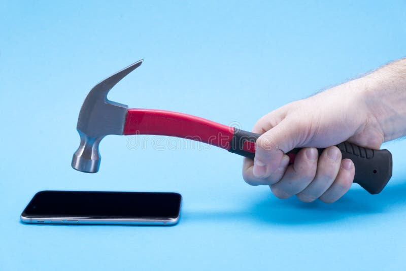 Male Hand with a Red Hammer Breaks a Mobile Phone on a Blue Background ...