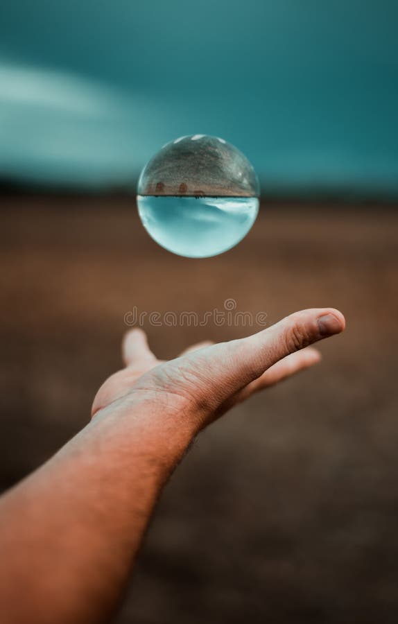 Male Hand Throwing a Crystal Ball Where the Upside-down Reflection of ...