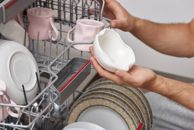 Man Unloading from Open Dishwasher Machine with Clean Utensils Inside ...