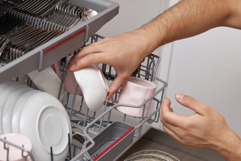 Man Unloading from Open Dishwasher Machine with Clean Utensils Inside ...