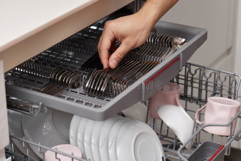 Man Unloading from Open Dishwasher Machine with Clean Utensils Inside ...