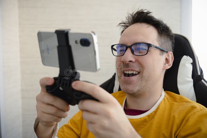 Male Hands with Game Controller Connected with Smartphone. Electronic ...