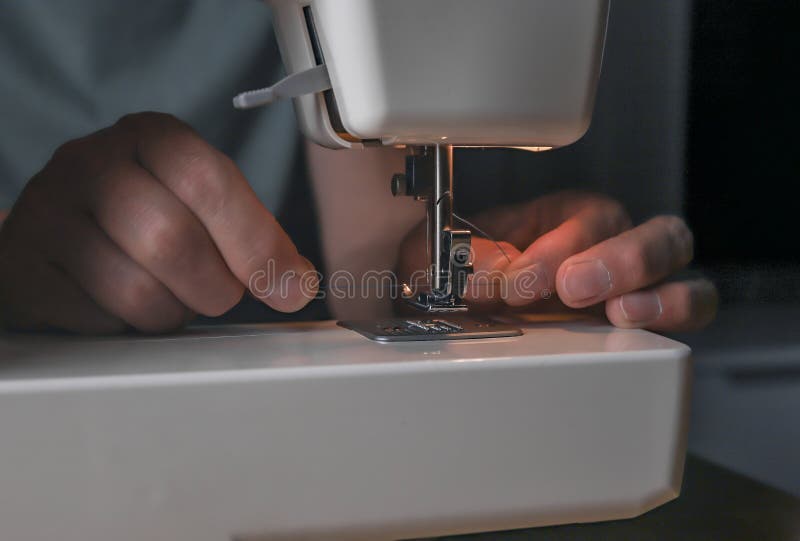 Male Hands Inserting Thread through Needle Hole in Sewing Machine ...
