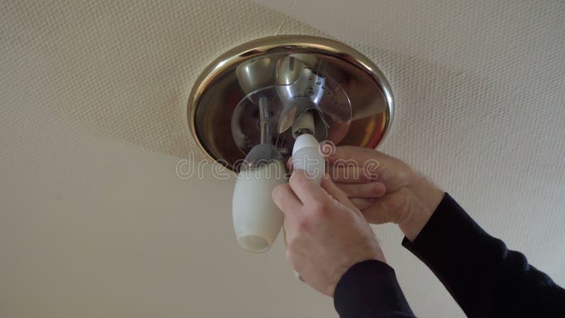 Male Hands Install an Energy-saving Diode Light Bulb in a Small Lamp on ...