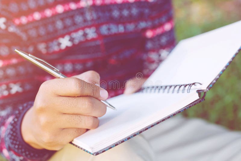 Male Hands with Pen Writing on Notebook Notepad Sitting in Public Park ...