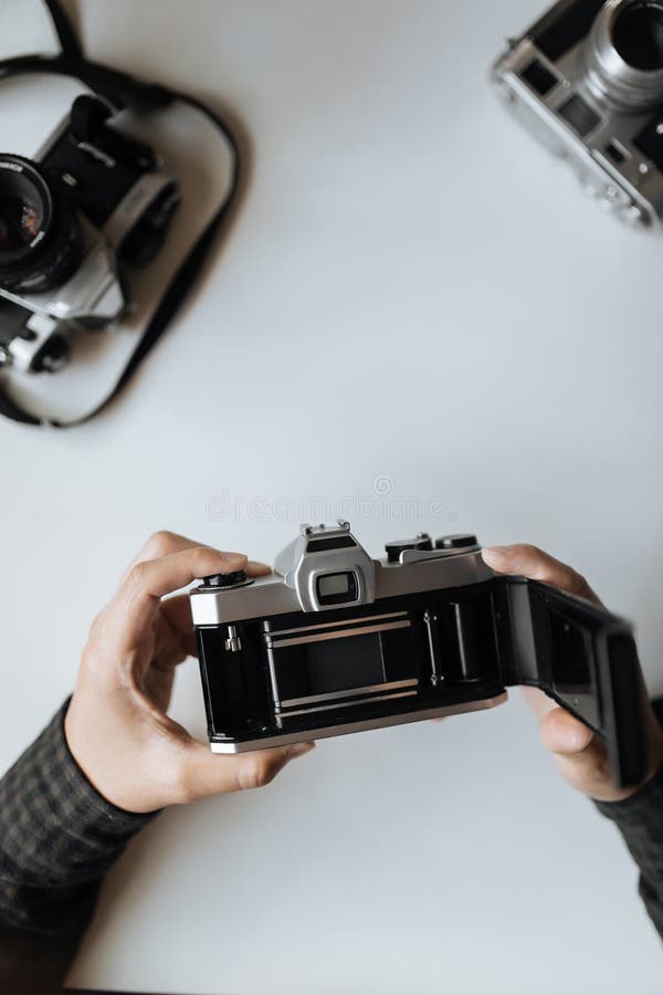 Male Hands Reloading Film Retro Camera on a White Table. Vertical Stock ...