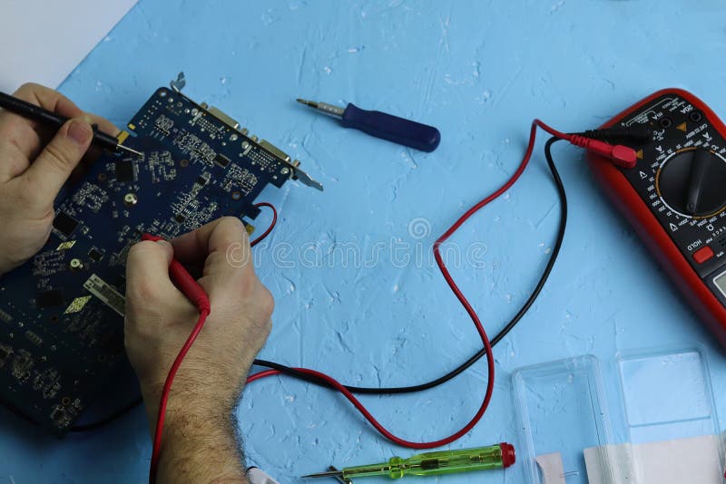 Male Hands Repair an Electronic Device Using Multimetr, Measuring the ...