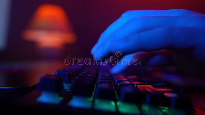 Male Hands Typing on Computer Keyboard in Neon Lighting. Hacker and ... Male Hands Typing on Computer Keyboard in Neon Lighting. Hacker and ...