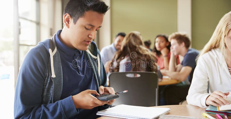 Male High School Student with Calculator Working at Desk Stock Photo ...