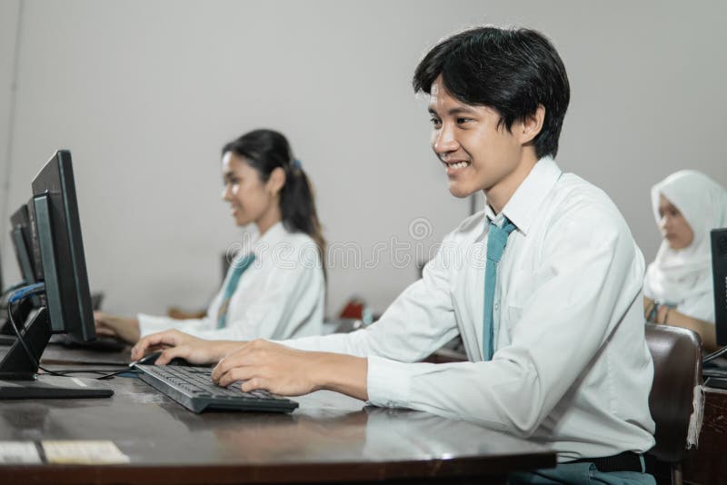 Male High School Students Smile while Using a Computer Pc with Their ...