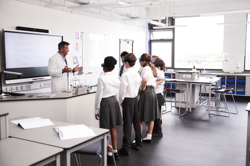 Female Student In Uniform Using Microscope In Science Class Stock Photo ...