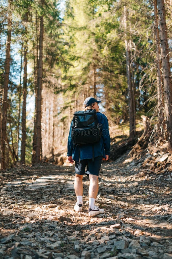 Male Hiker with a Backpack on His Back Walks on a Mountain Trail ...