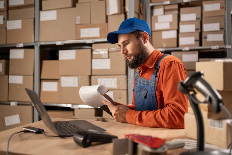 Male Inventory Manager Checking Inventory and Writing into an ...