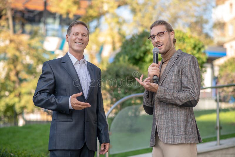 Male Journalist Doing Inteview with Mature Man Outside Stock Image ...